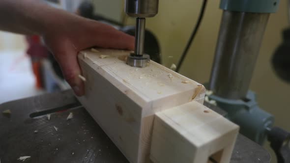 Drilling out a tenon slot in a wood beam on a drill press in slow ...