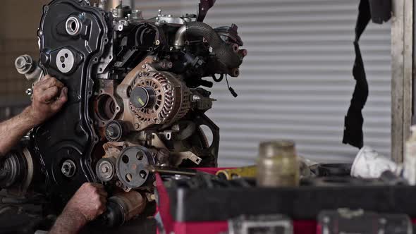 Car Mechanic Installs Front Housing Of Car Engine In The Repair Shop ...