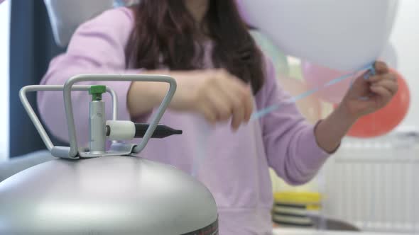 Woman Using Helium Tank Blowing Up Balloons to Decorate Home for Party ...