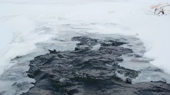 Thawed ice on river, rapid flow of water under ice in winter, spring ...