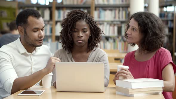 Thoughtful People Talking While Using Laptop at Library, Stock Footage