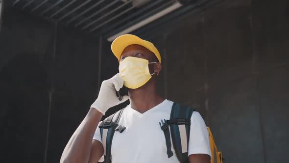 Portrait of an Afro Courier in a Cap and Protective Mask Glorifying ...