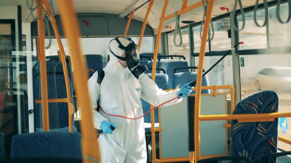 A Person in a Hazmat Suit Is Disinfecting Bus Windows. Coronavirus ...