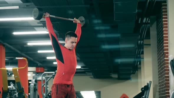 Young Man is Lifting a Bar in the Fitness Center, Stock Footage | VideoHive