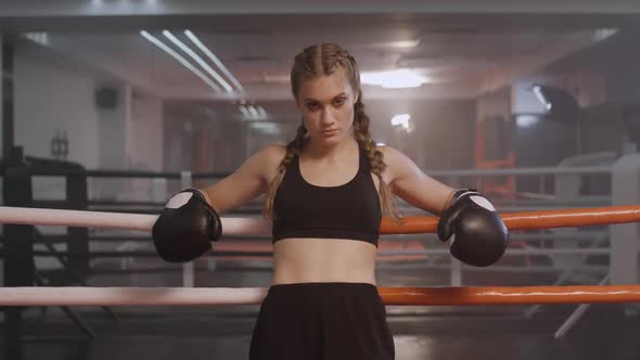 Female Fighter Stands Near the Boxing Ring After Training and Looks at ...