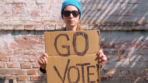 Woman shows cardboard Go Vote sign Voting balloting polling Political ...