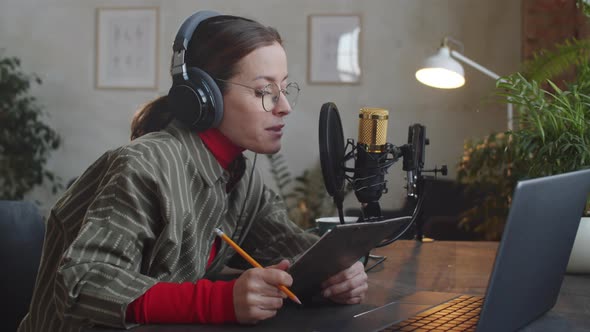 Female Podcast Host Reading Speech from Paper in Recording Studio ...