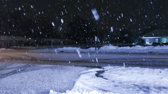 Giant snowflakes falling across a parking lot through the street lights ...