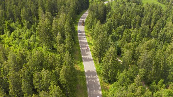 Aerial View Flying Over Two Lane Forest Road with Car Moving Green ...