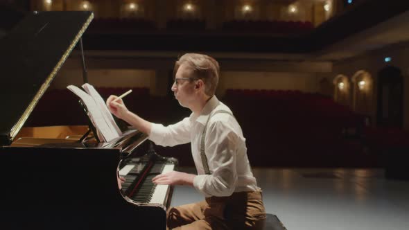 Composer Writing Music at Grand Piano in Concert Hall, Stock Footage