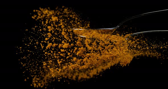 Spoon and Curry Powder falling against Black Background, Slow motion 4K ...