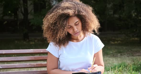 Pensive Mixed Race Female Handwriting Paper Notes in Notepad Page Use ...