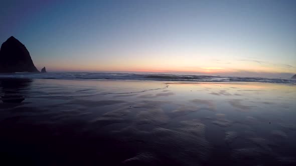 Panning time lapse of the setting sun and incoming tide at Cannon Beach ...
