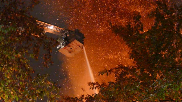 Firefighters extinguishing large fire from above on a crane, many ...
