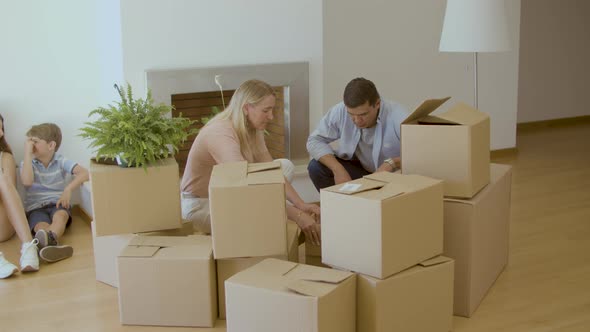 Man and Woman Taking Things Out of Carton Boxes After Moving, Stock Footage
