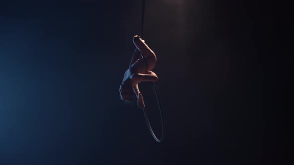 A Young Woman Gymnast Performs Acrobatic Stunts on an Air Hoop Under ...