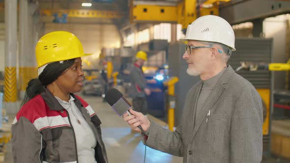Female Factory Worker Giving Interview to TV Reporter, Stock Footage