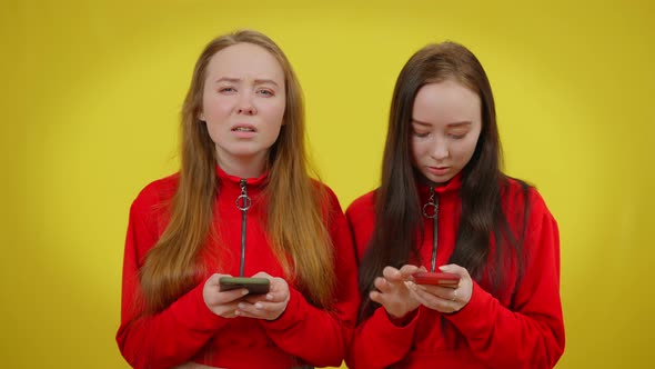 Absorbed Twin Sisters Texting Fast on Smartphones Looking at Camera ...