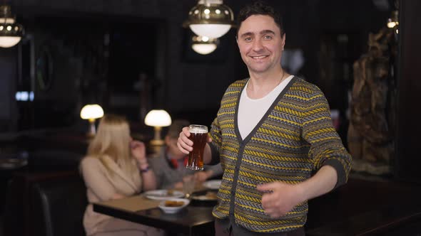 Portrait of Happy Man with Pint of Beer Gesturing Thumb Up Looking at ...