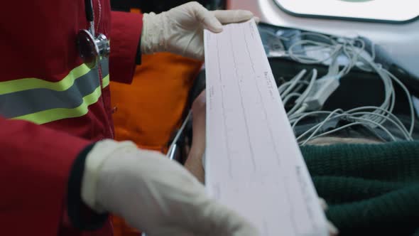 Crop Paramedic Reading ECG Stripe, Stock Footage | VideoHive