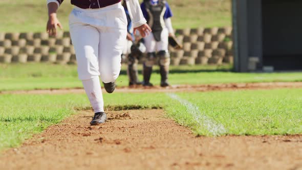 Low section of female baseball players playing on the field, hitter ...