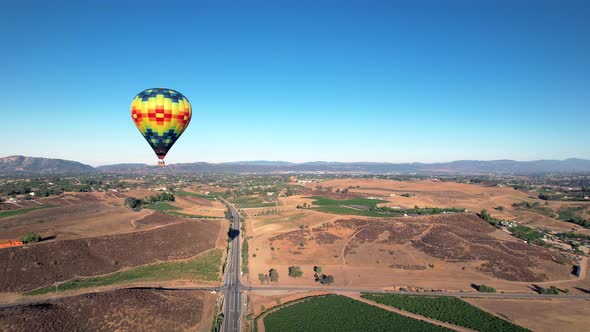 Flying by a hot air balloon floating over the Temecula vineyards in ...