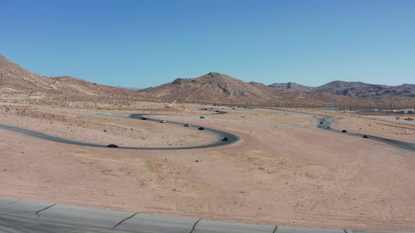 Cars race for the championship at a racetrack with the Mojave Desert ...