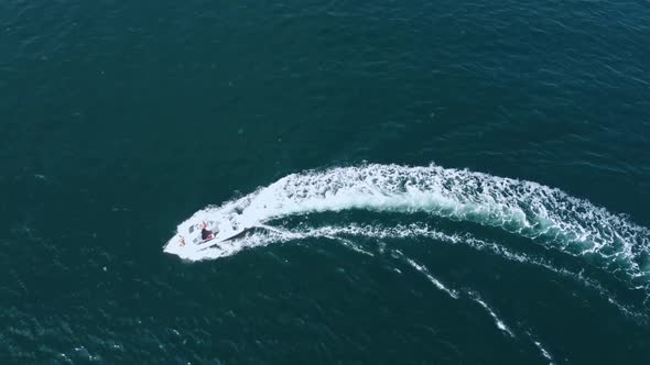 Aerial view of a speedboat moving in a circle for a turn, with a man ...