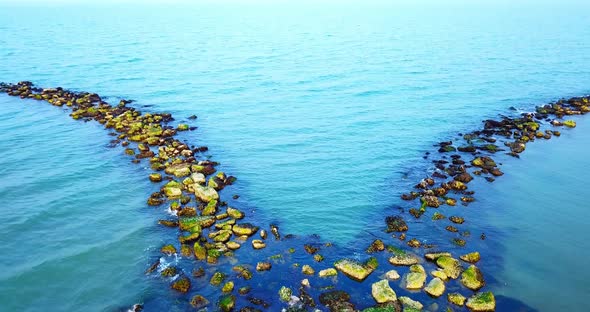 Artificial Rock Breakwater Splits Against Endless Blue Sea, Stock Footage