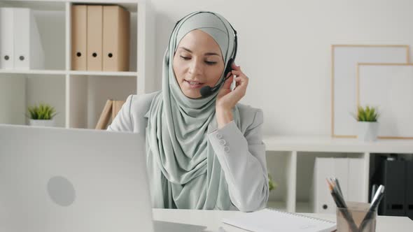 Modern Muslimah in Hijab Talking to Customer Working in Call Center ...