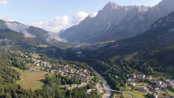 Flying over a small village in the Dolomites mountains - Borca di ...