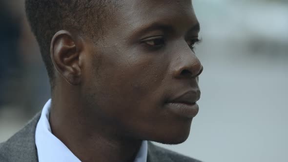 handsome black african man turning his head and looking at camera ...