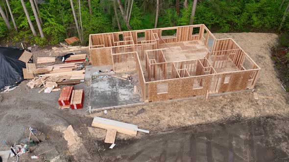 Orbiting overhead aerial of a framed single story house awaiting all of ...