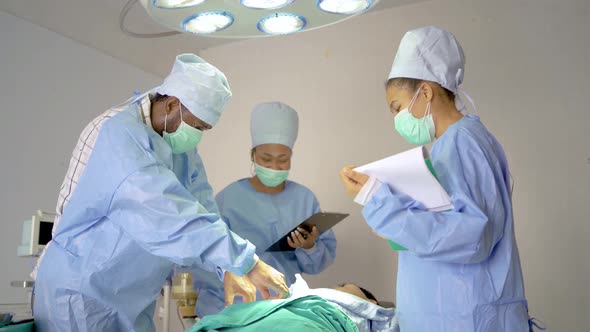 Professional surgeon teaching young medical interns performing organ ...