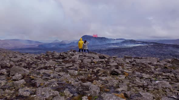 Drone View of Adventurers on a Vast Rocky Field with Erupting Volcano ...