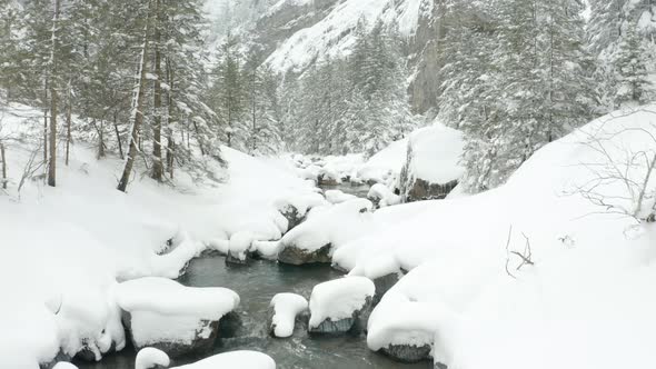 Flying low over small stream in snow covered landscape, Stock Footage