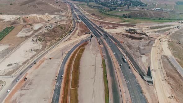 Aerial footage of large highway construction project with tunnels and ...