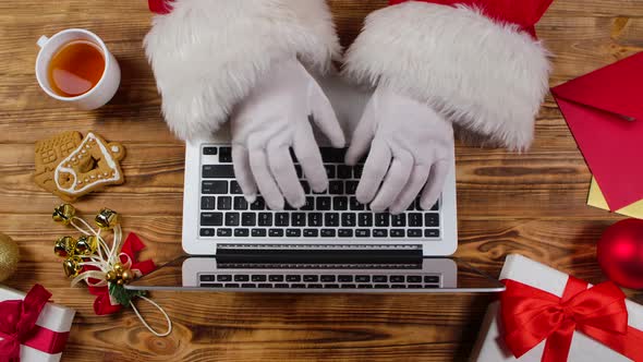 Top View Santa Hands Typing on Keyboard and Drinks Tea By Wooden ...