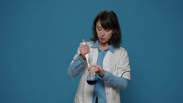 Woman Scientist Using Micro Pipette to Drip Liquid in Beaker, Stock Footage