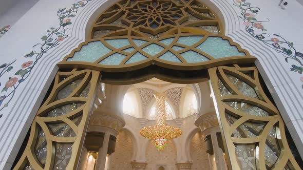 Entering the Sheikh Zayed Grand Mosque in Abu Dhabi through a golden ...