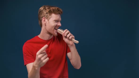 Young Attractive Man with Ginger Hair Positively Singing Into a Brush ...