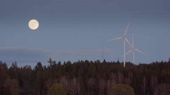 FULL MOON, TWILIGHT - Wind turbines spin fast next to a rising full ...