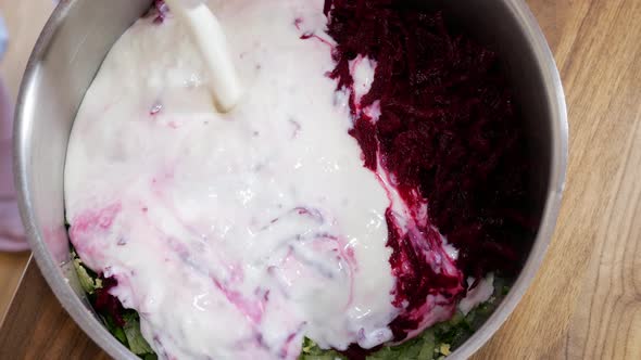Pouring kefir into bowl with ingredients for cold beetroot soup, static ...