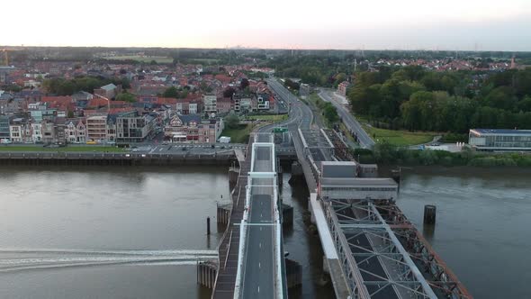 Boat speeding under city bridge, aerial drone view with city skyline ...