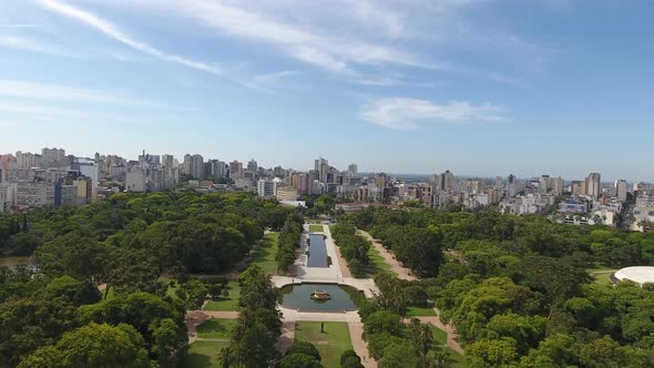 Park in center of city. Green area surrounded by a city. Blue sky with ...