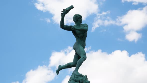 Bronze Statue Of Brabo Monument Against Blue Sky With Clouds In Antwerp ...