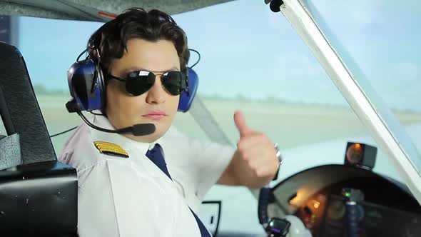 Serious Pilot in Sunglasses Making Thumbs Up Hand Sign, Plane Ready for ...