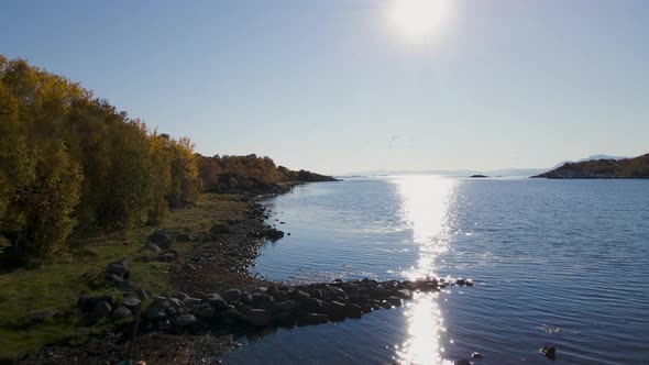 Clean And Serene Ocean Water By The Coast Of Senja Island In Sunset ...