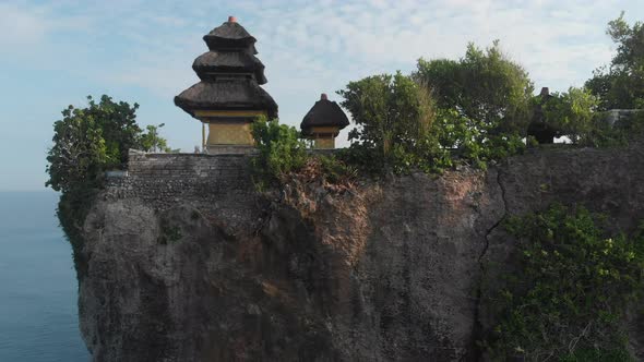 Aerial Flying Low Rising Up Vertically past cliff showing a temple and ...
