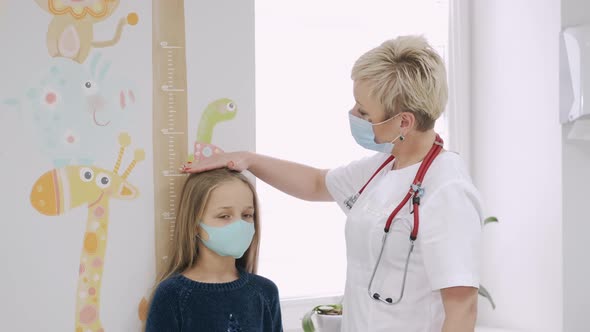 Friendly Paediatrician Measuring Little Girl's Height at a Consult ...